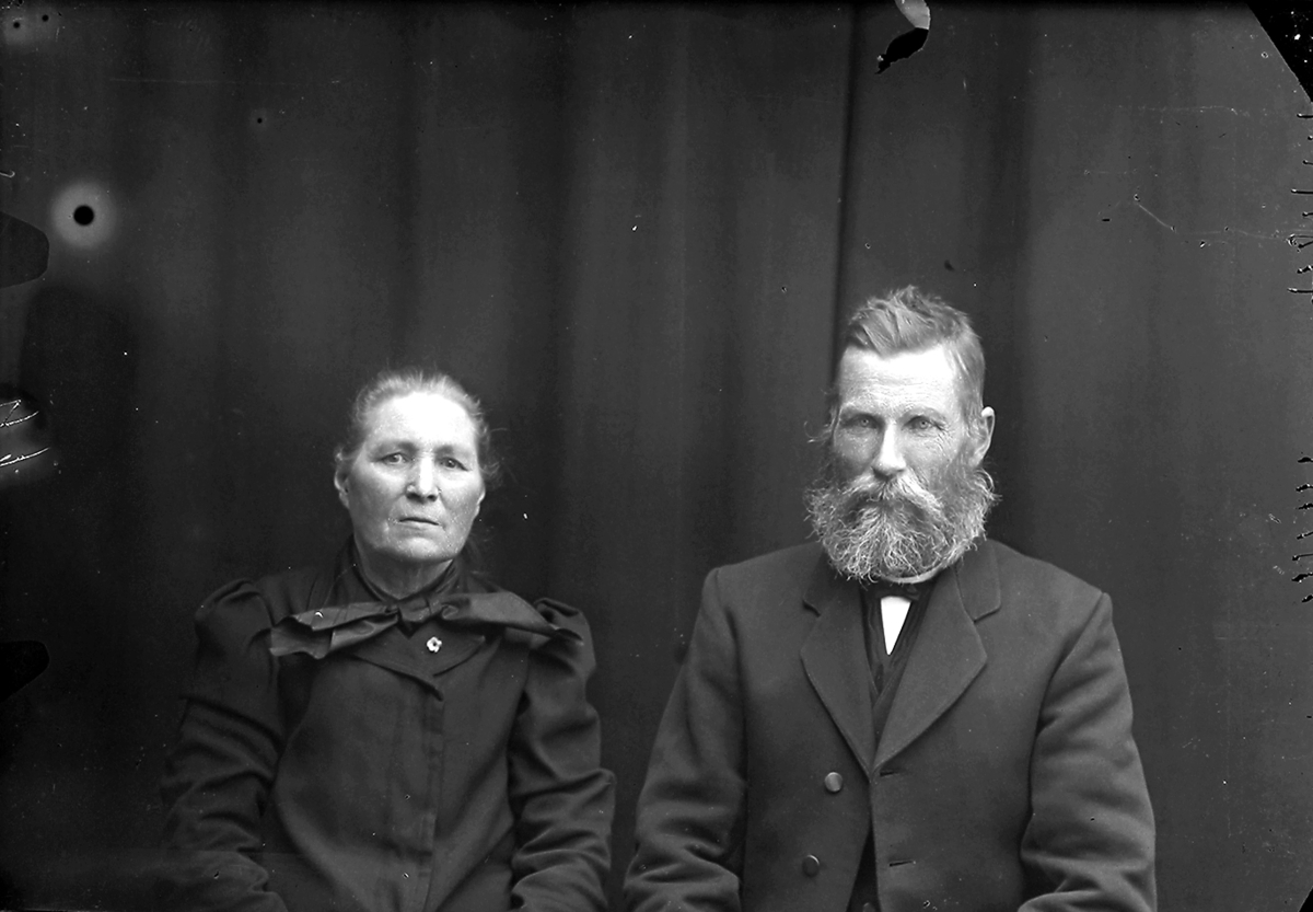 Portrett. Par i 70-åra. Begge sitter. Mannen har skjegg. Bildet er tatt ...