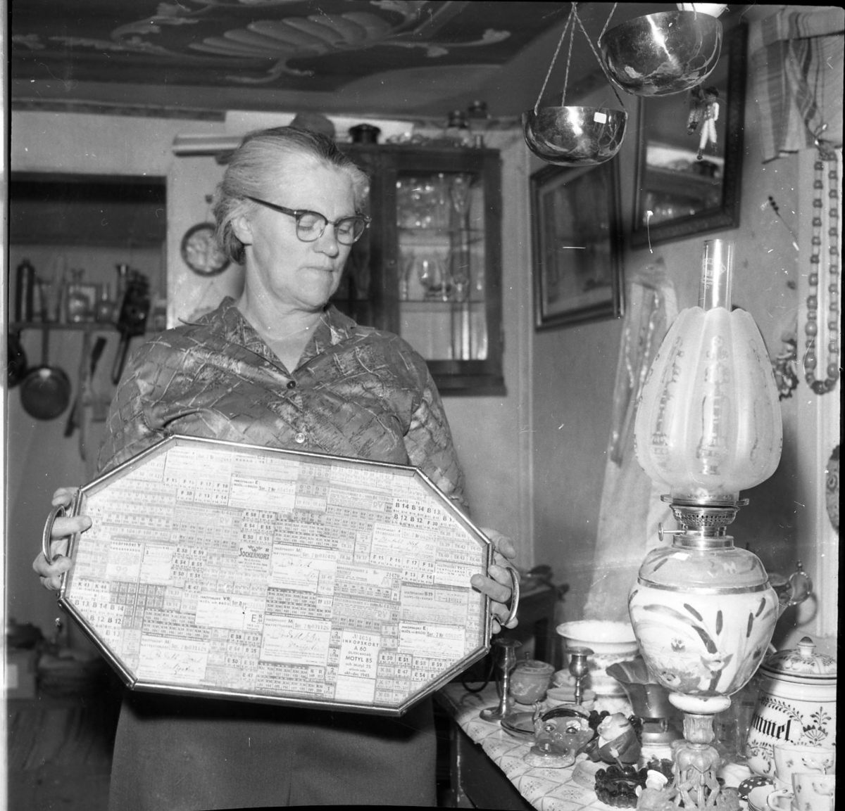 En kvinna visar upp en bricka. Brickan har motivet av ...