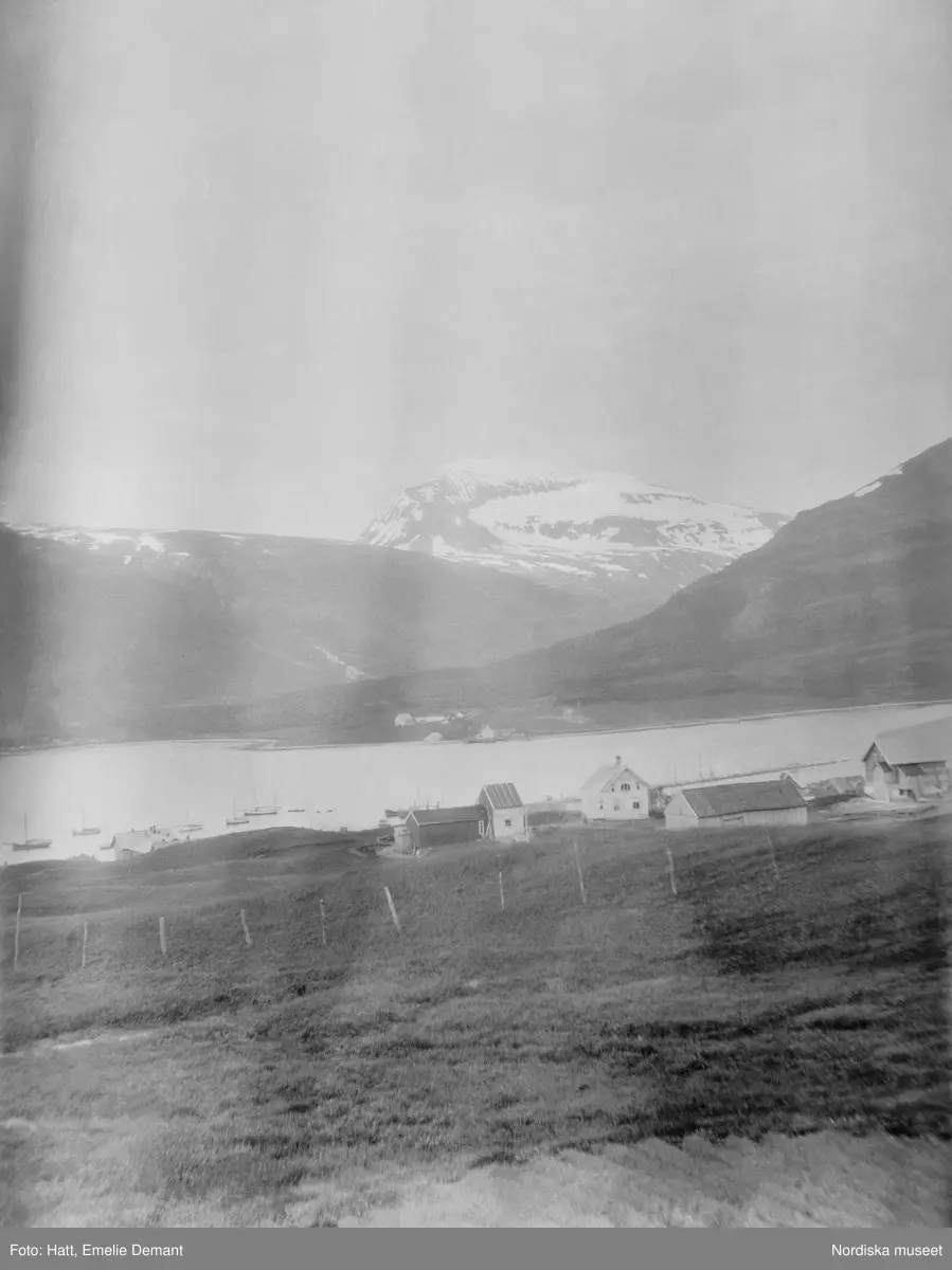 Vy över bebyggelse, åkrar, vatten och fjäll i Norge. Bygden som idag är ...