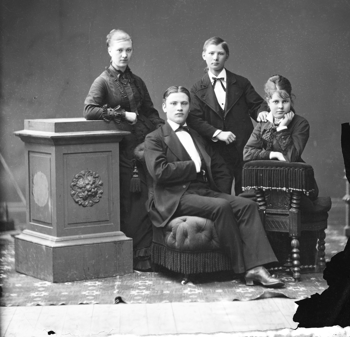 Ateljéfoto med fyra av barnen till Wilhelm Ranch vid 1870-talets slut. Djonn Ranch sitter och ...