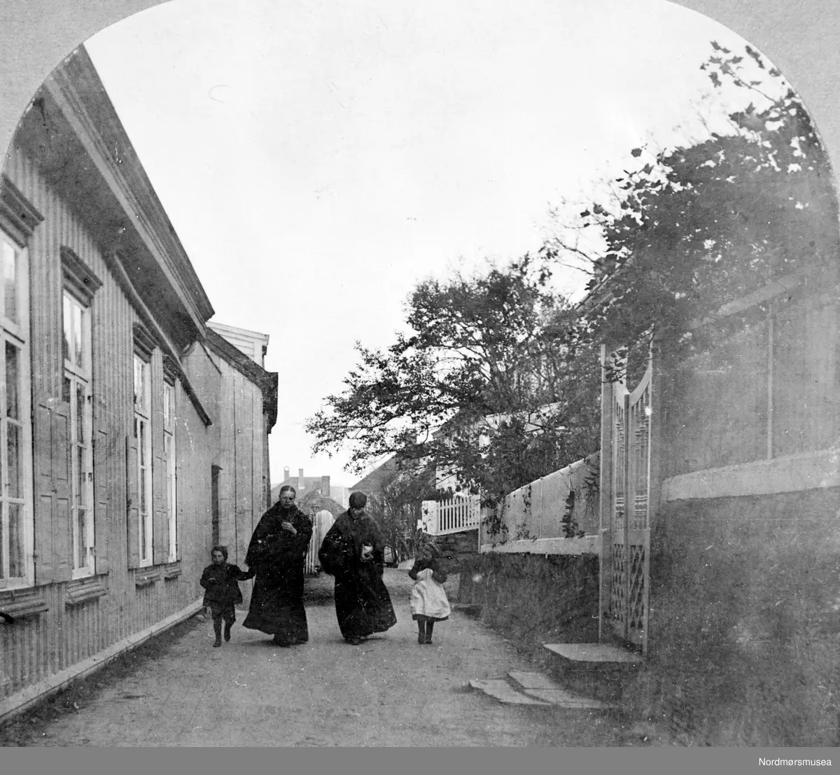 To kvinner og to barn i en bygate. Fra Nordmøre Museum sin fotosamling ...