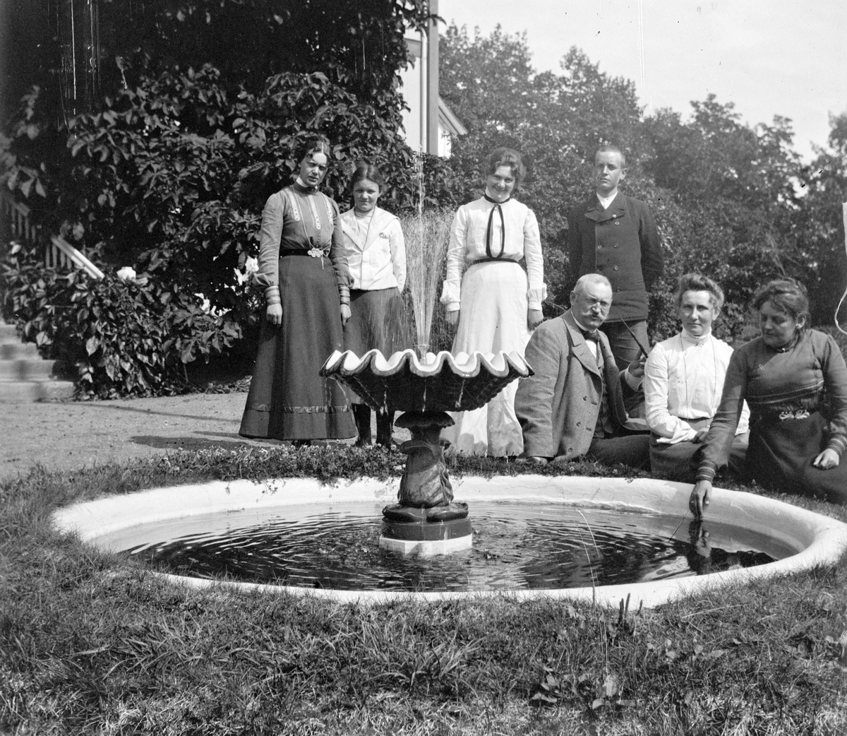 Familiegruppe ved fontenen, springvannet, ved Hovelsrud gård, Helgøya i ...